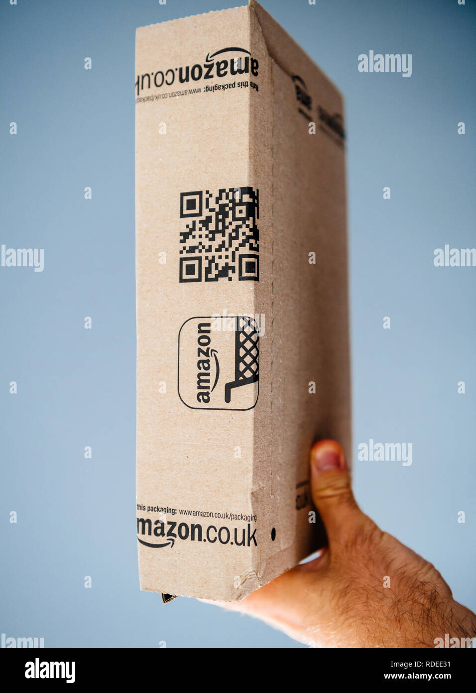 PARIS, FRANCE - APR 24, 2018: Man holding the side view of Amazon prime ...