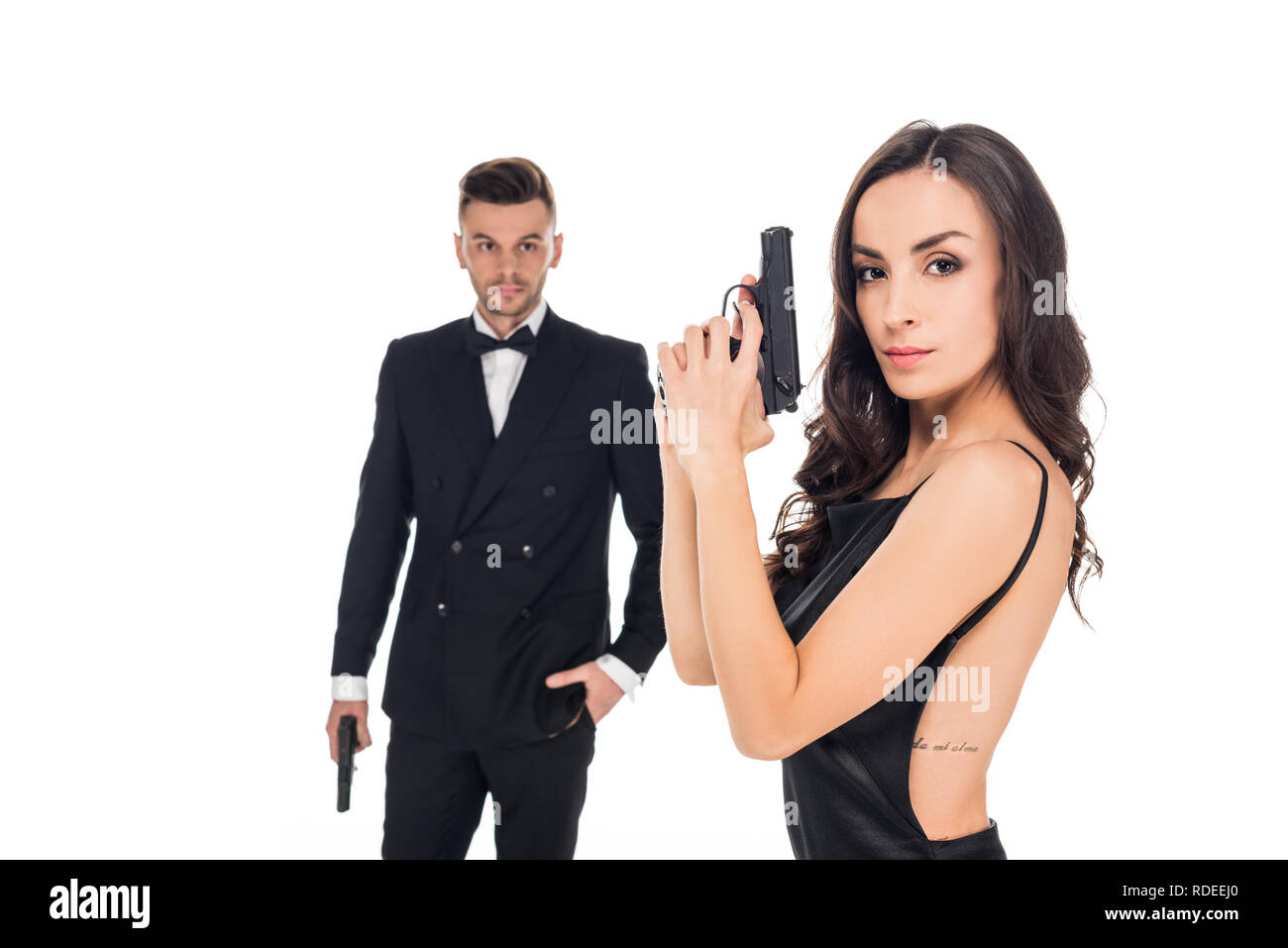 couple of secret agents in black clothes posing with guns, isolated on ...