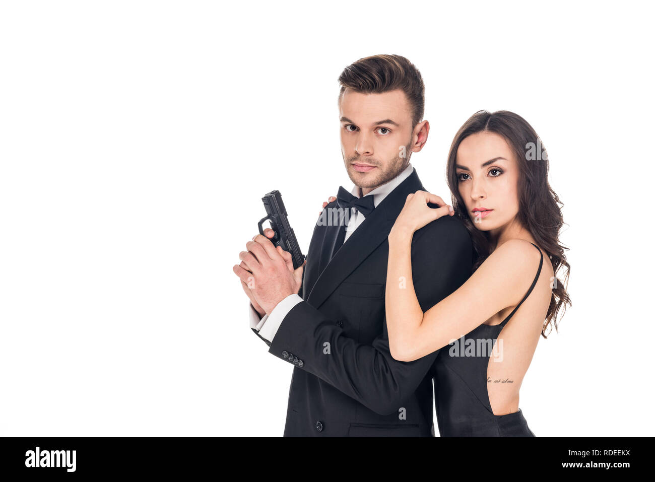 beautiful woman embracing male secret agent with gun, isolated on white ...