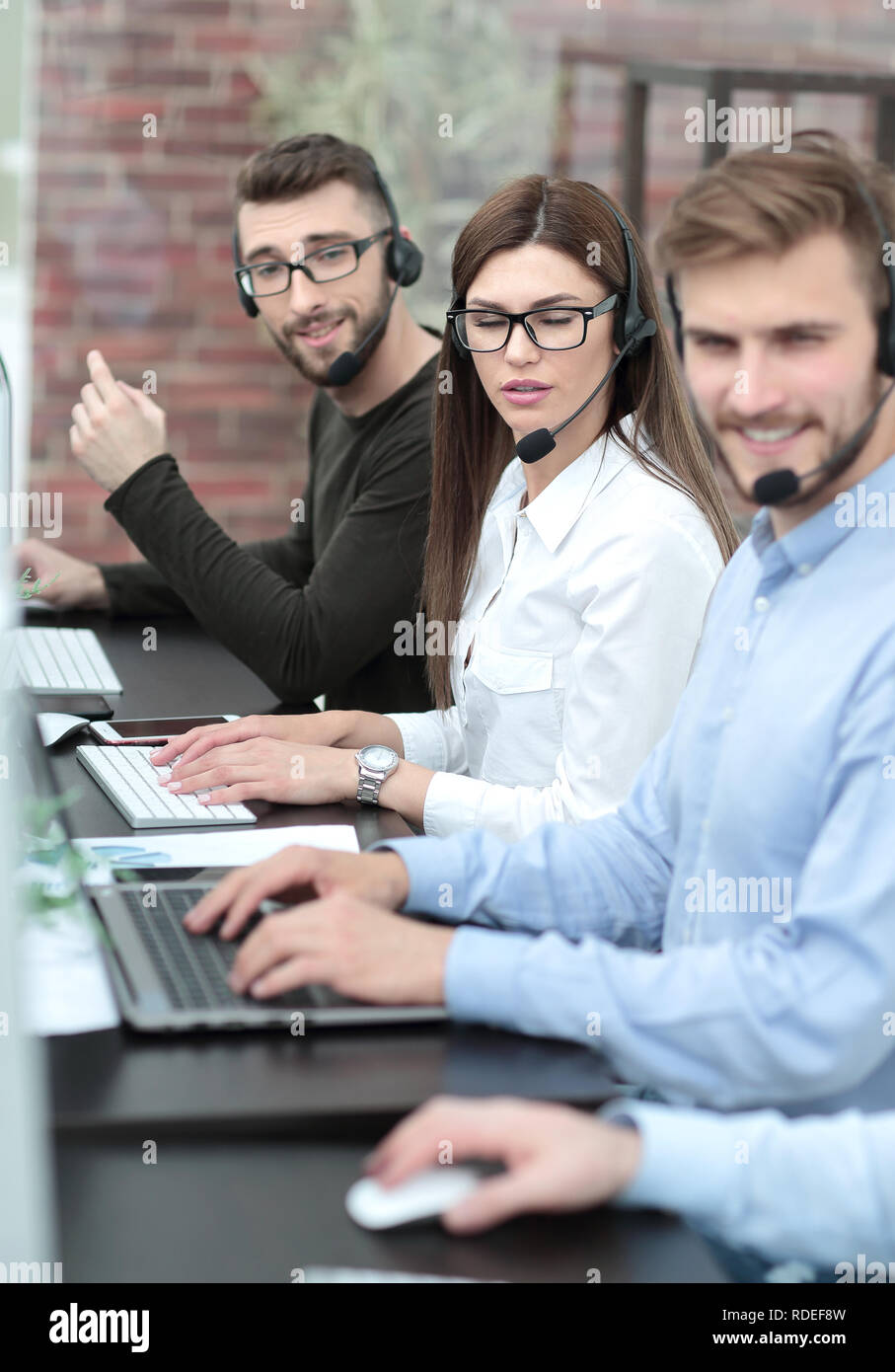 close up.call center operators sitting at the Desk Stock Photo - Alamy