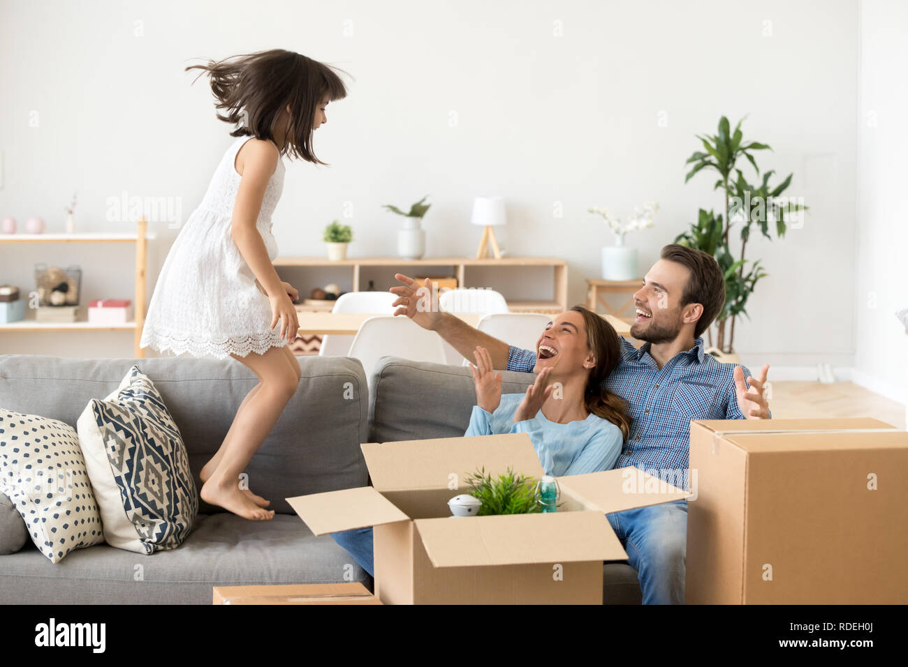 Kid girl having fun jumping on sofa on moving day Stock Photo - Alamy