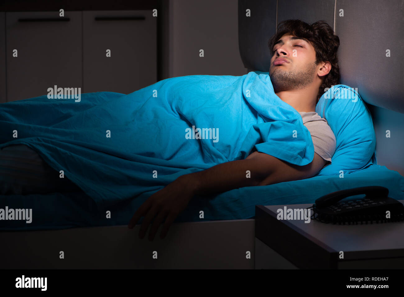 Tired exhausted man sleeping in his bed Stock Photo - Alamy