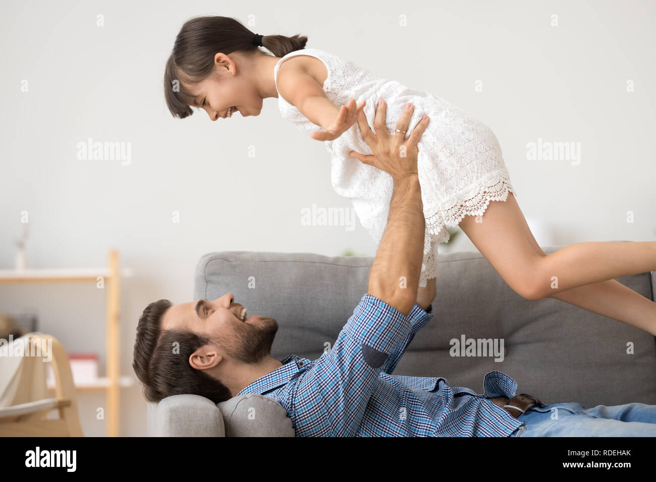 Happy dad lifting up child daughter flying having fun together Stock ...