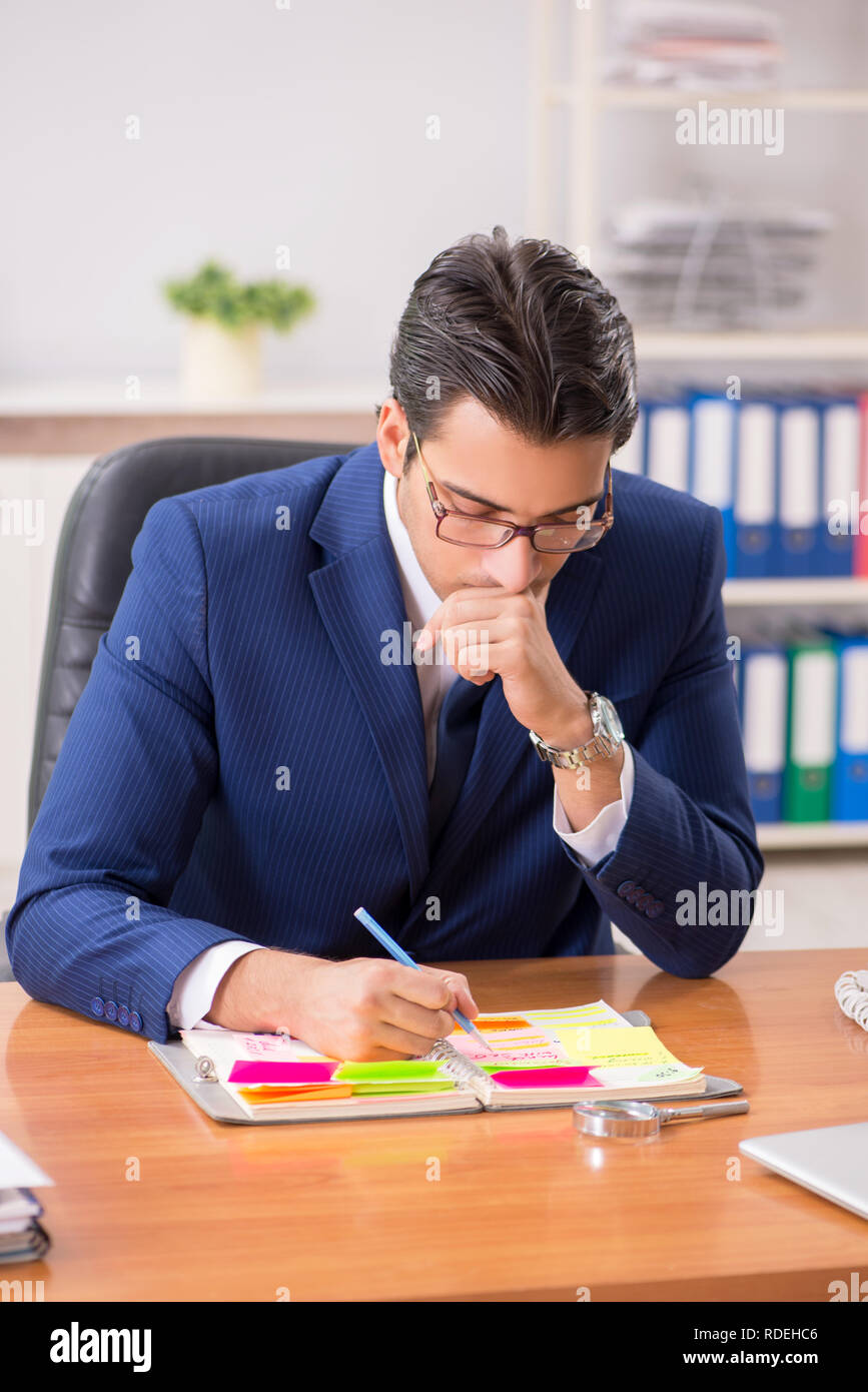 Young handsome employee planning his work activity Stock Photo - Alamy