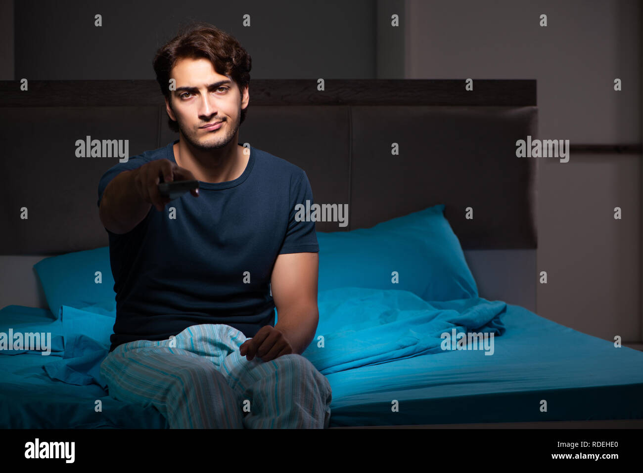 Man watching tv at night in bed Stock Photo - Alamy