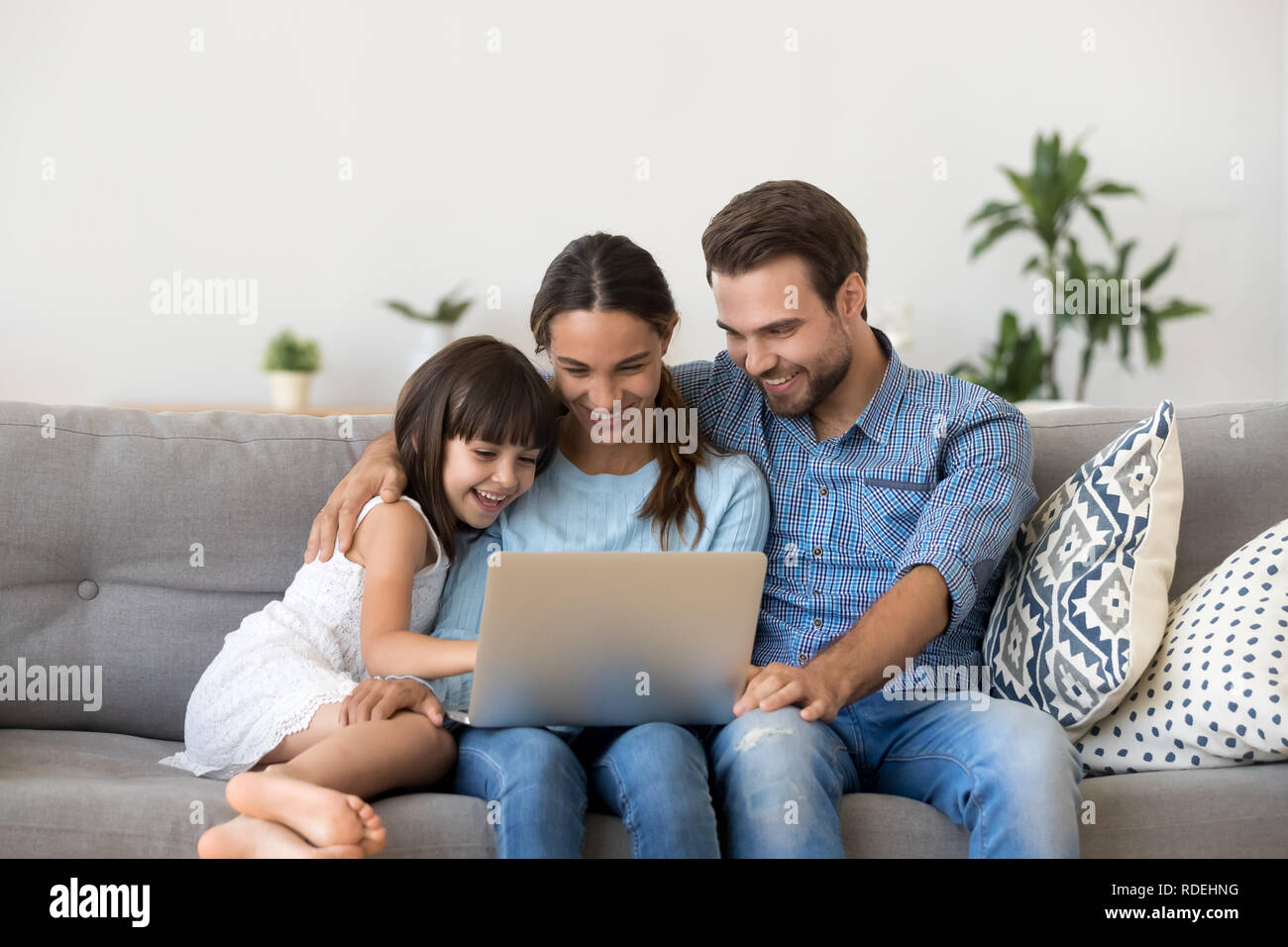 Happy family with kid girl having fun using laptop together Stock Photo ...
