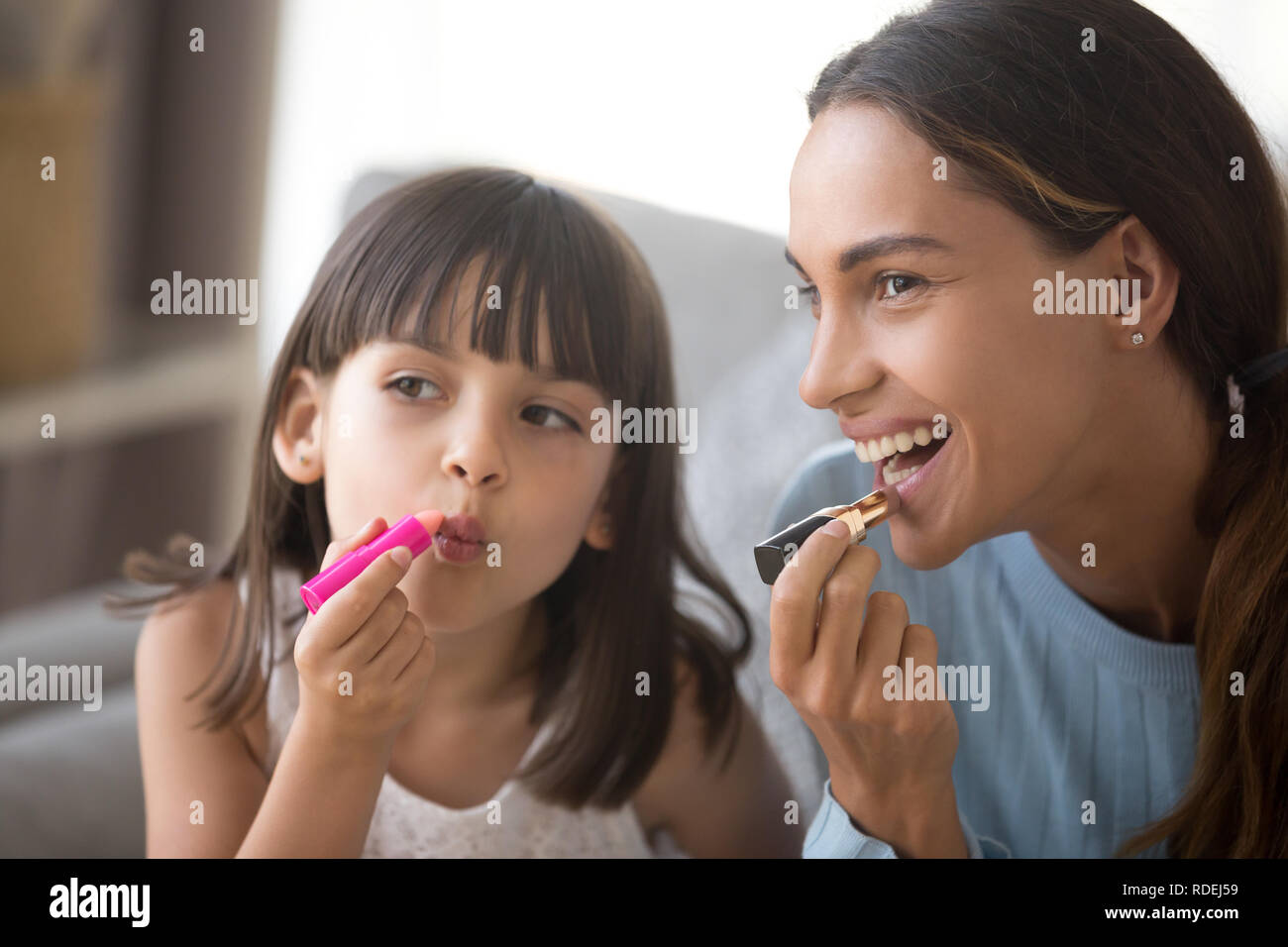 Happy mom and kid daughter having fun doing makeup together Stock Photo ...