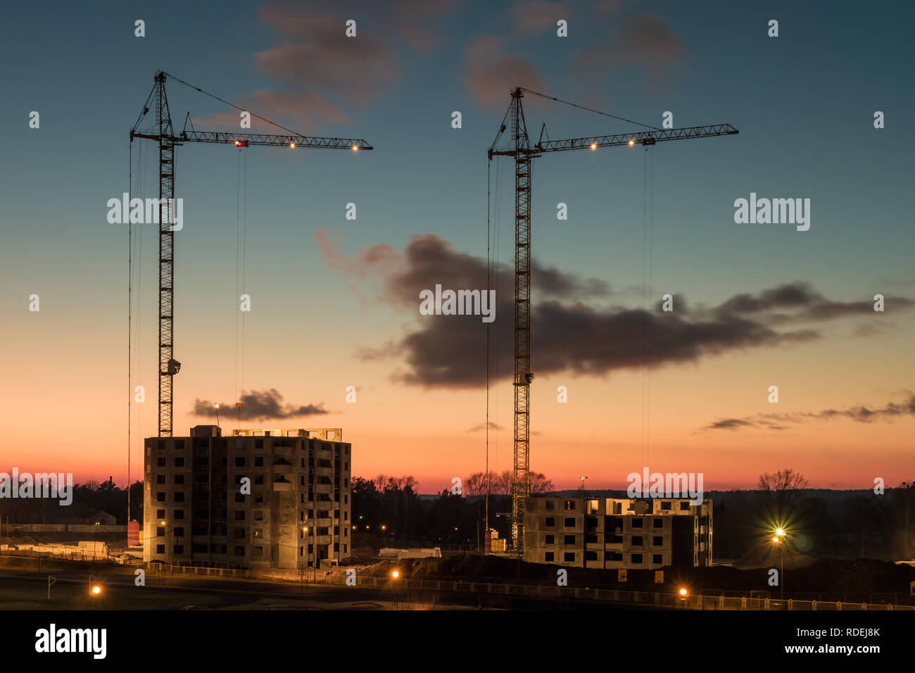 Silhouette tower cranes and unfinished multi-storey high buildings ...