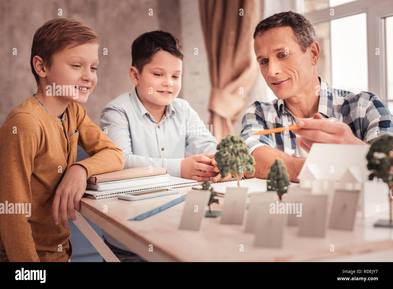 Smiling foster father feeling cheerful spending time with children ...