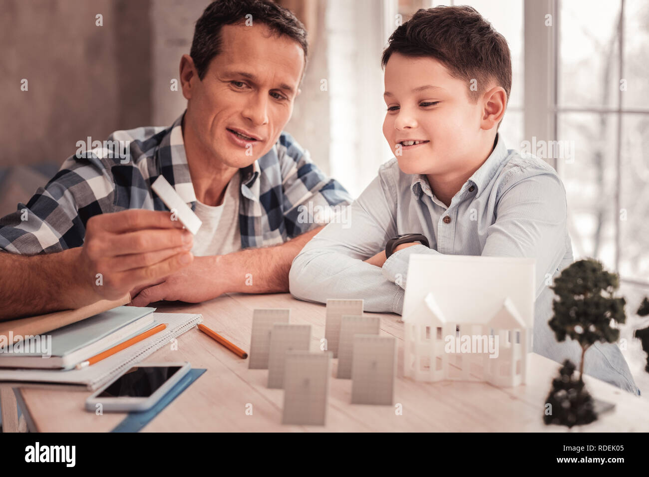 Foster father and his cute son building model of smart city Stock Photo ...