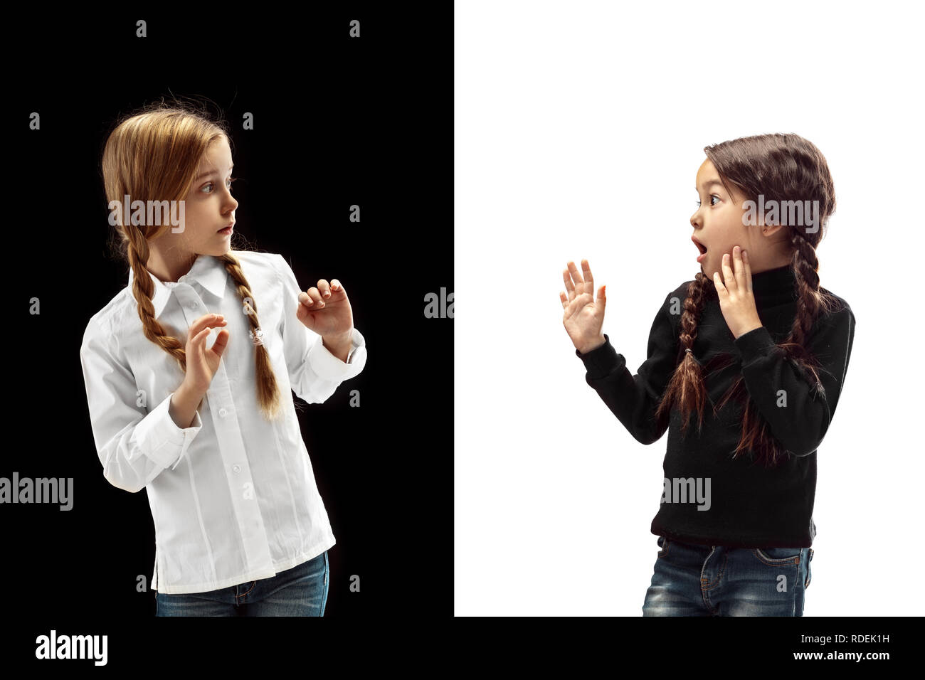 The portrait of two frightened, afraid, scared girls on a white and ...