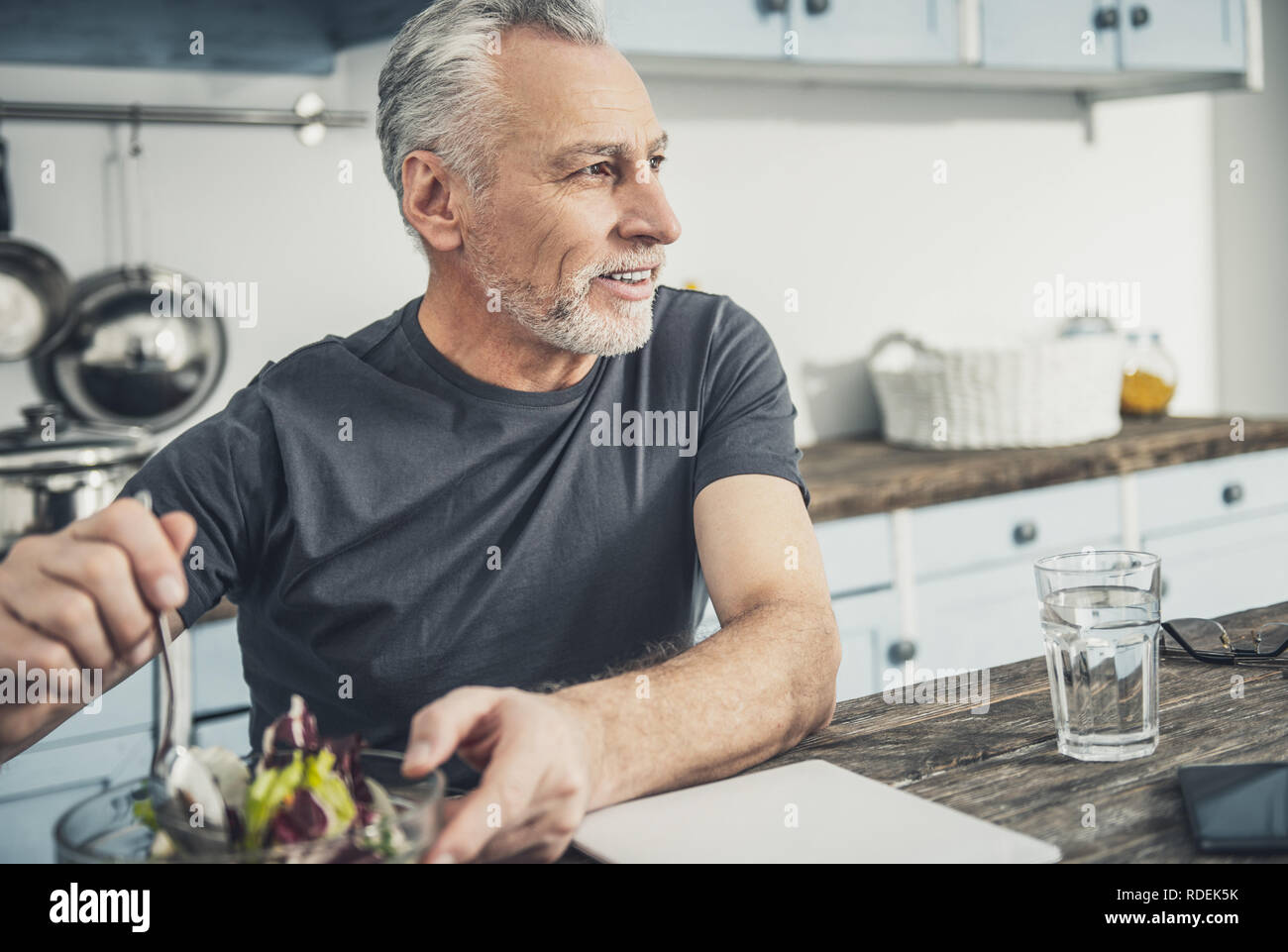 Beaming happy man eating vegetable salad Stock Photo - Alamy