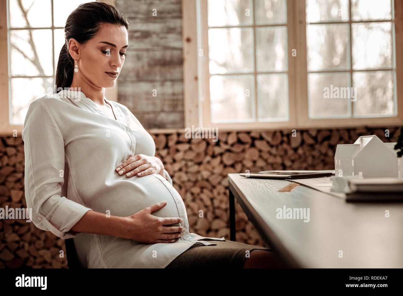Nice young woman looking at her belly Stock Photo - Alamy