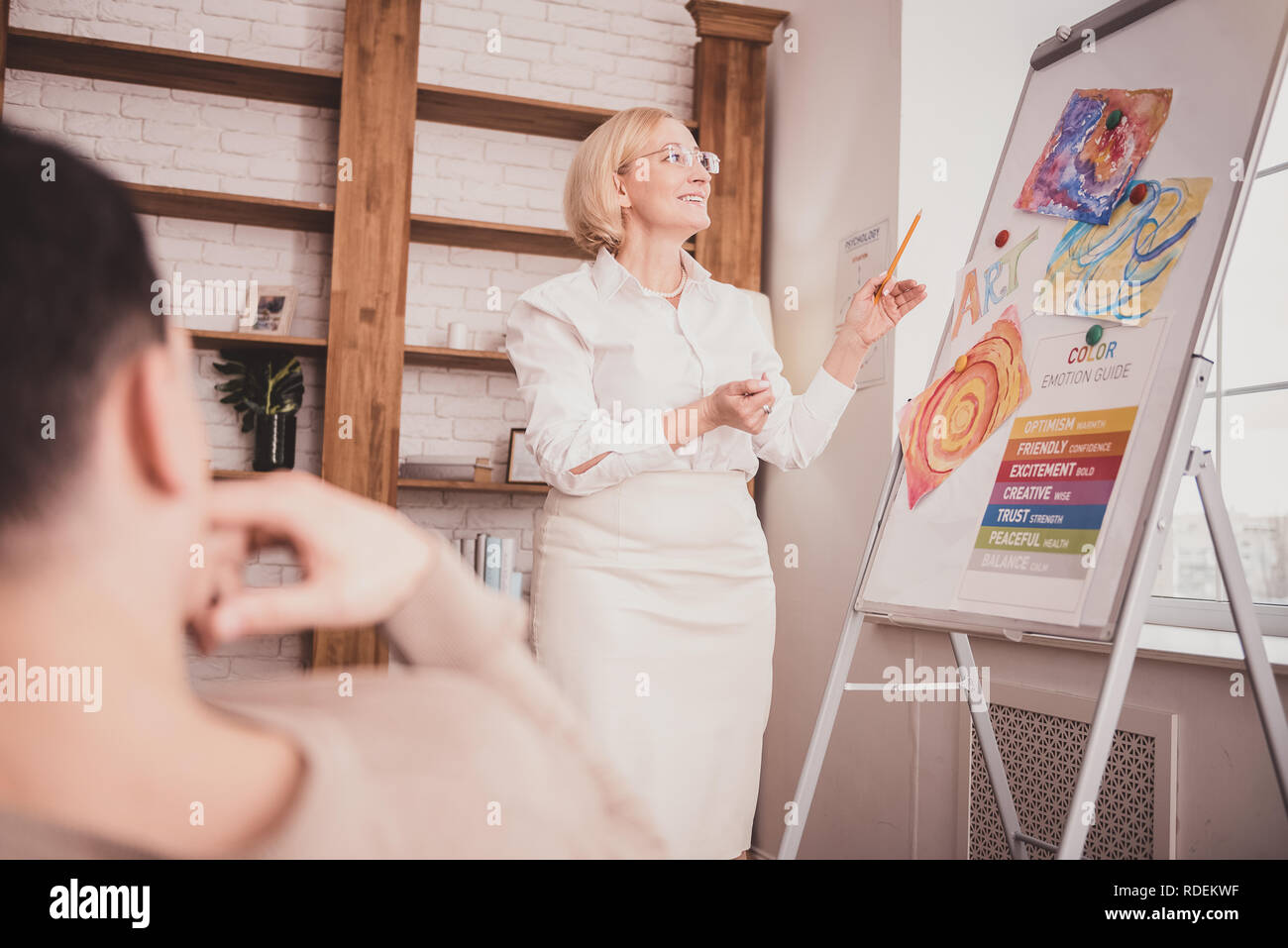 Pretty blonde woman demonstrating pictures for discussion Stock Photo ...