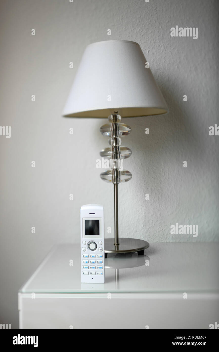 Front view of modern white cordless phone on white living room office ...