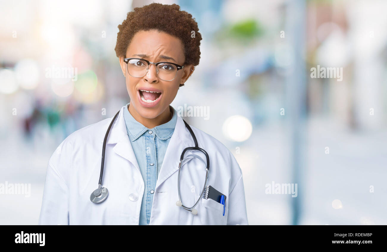 Young african american doctor woman wearing medical coat over isolated ...