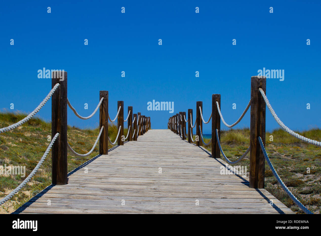 Wooden path beach rope blue sky Stock Photo - Alamy