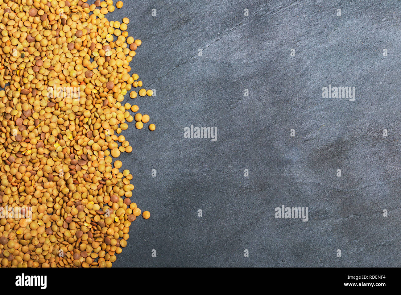 Raw lentils on balck stone background. Healthy vegetarian food concept ...