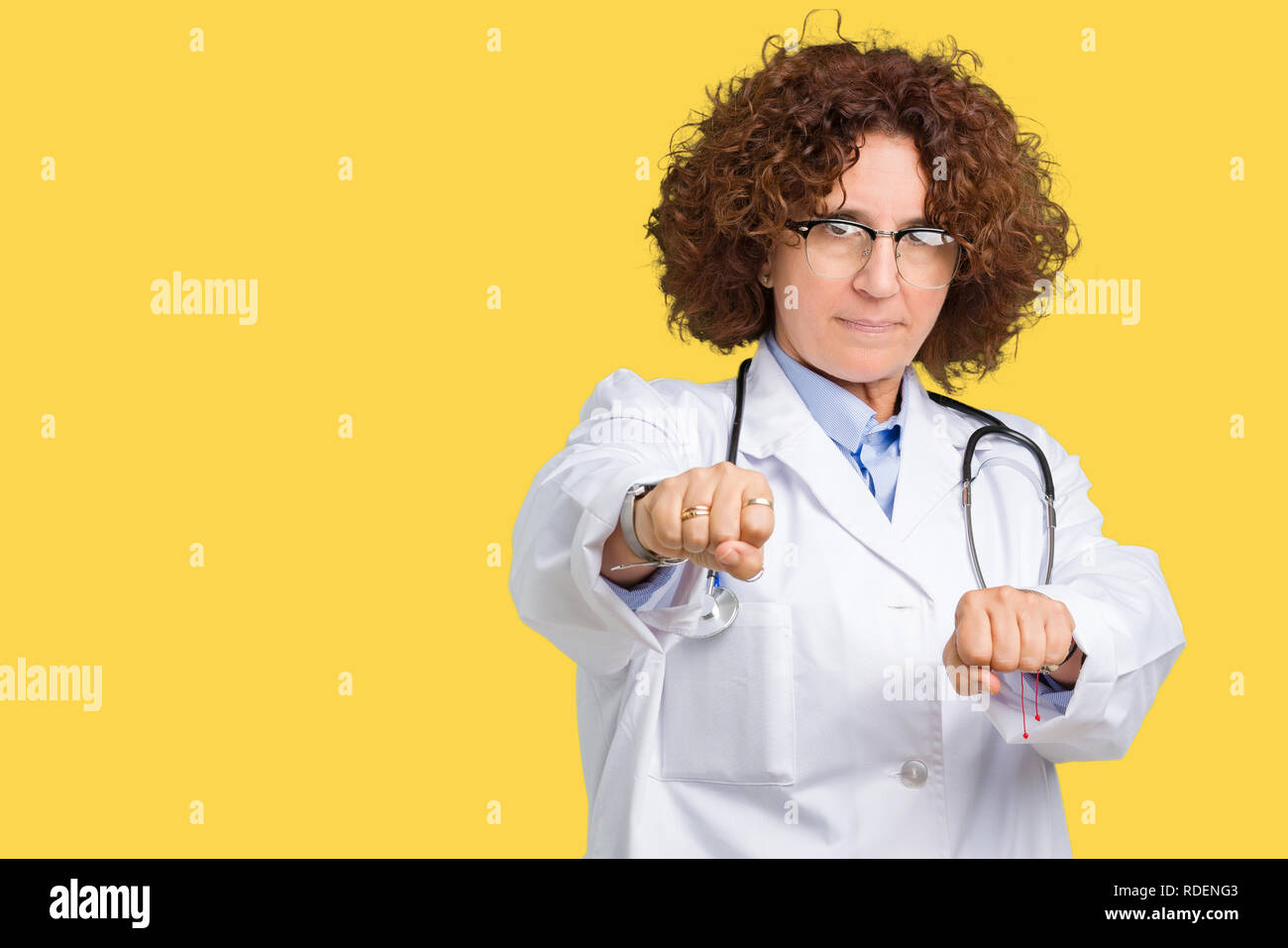 Middle ager senior doctor woman over isolated background Punching fist ...