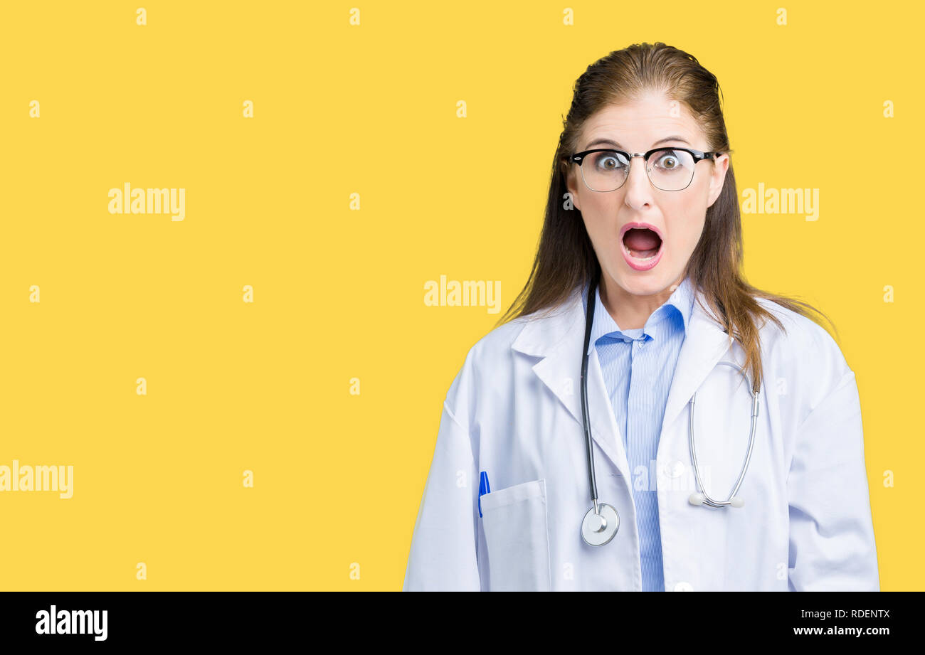 Middle age mature doctor woman wearing medical coat over isolated ...