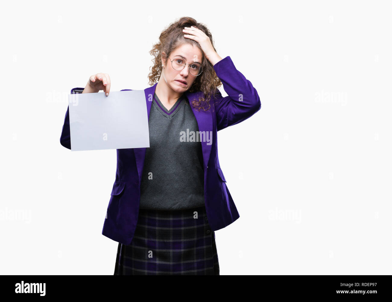 Young brunette student girl wearing school uniform holding blank paper ...