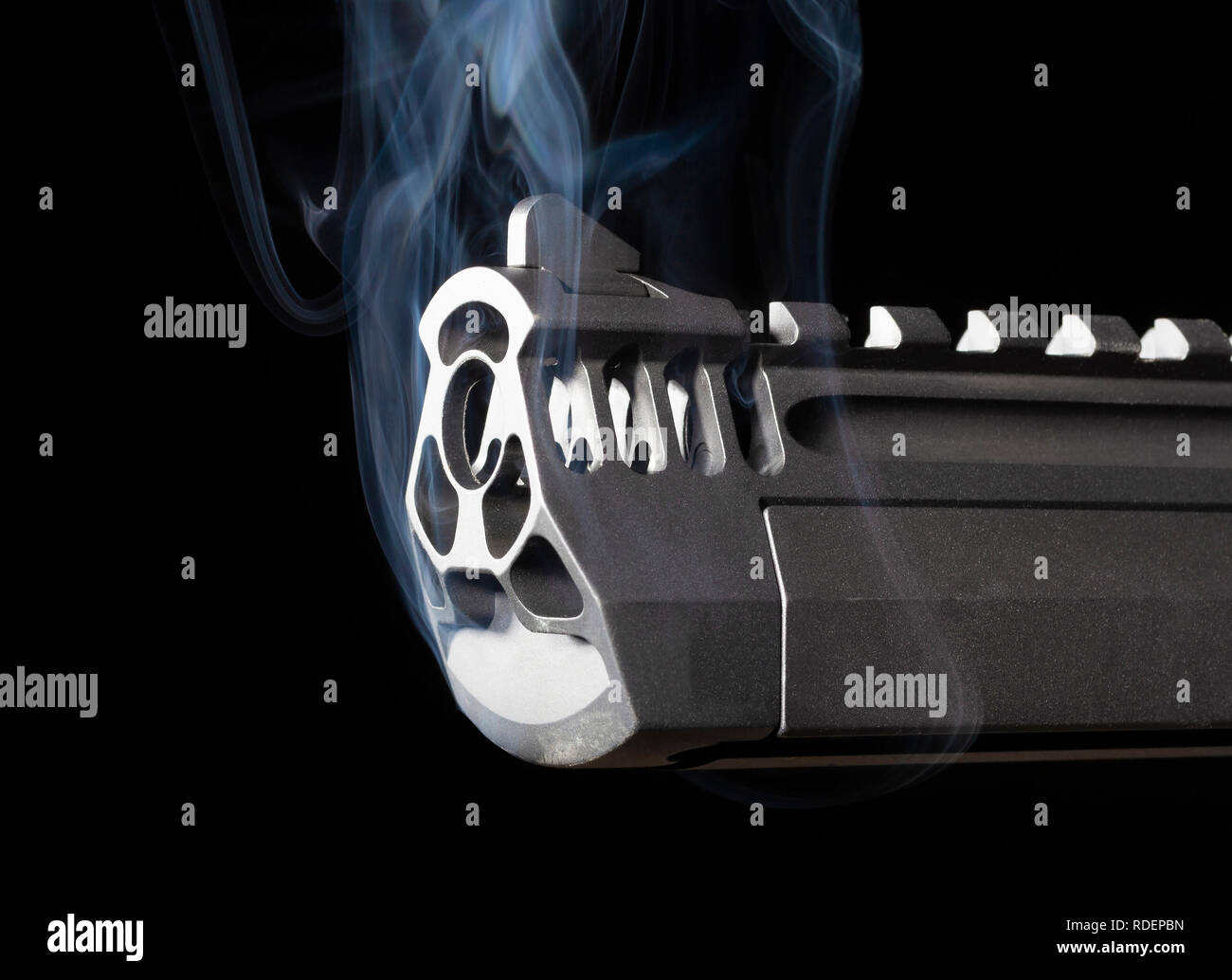 Firearm with smoke rising on a black background Stock Photo - Alamy
