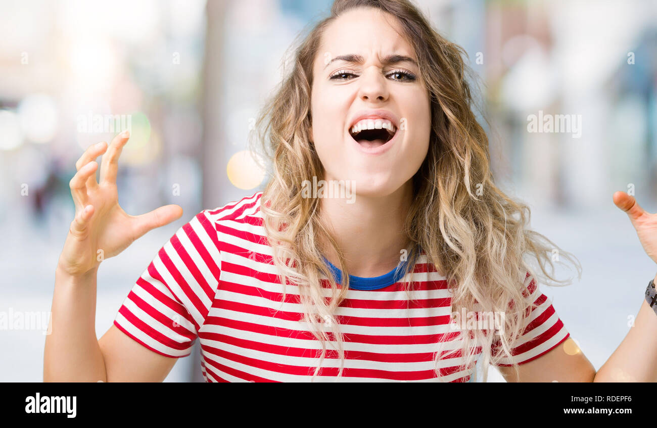 Beautiful young blonde woman over isolated background Shouting ...