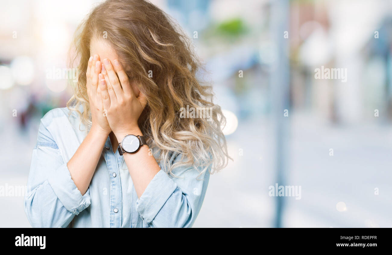 Beautiful young blonde woman over isolated background with sad ...