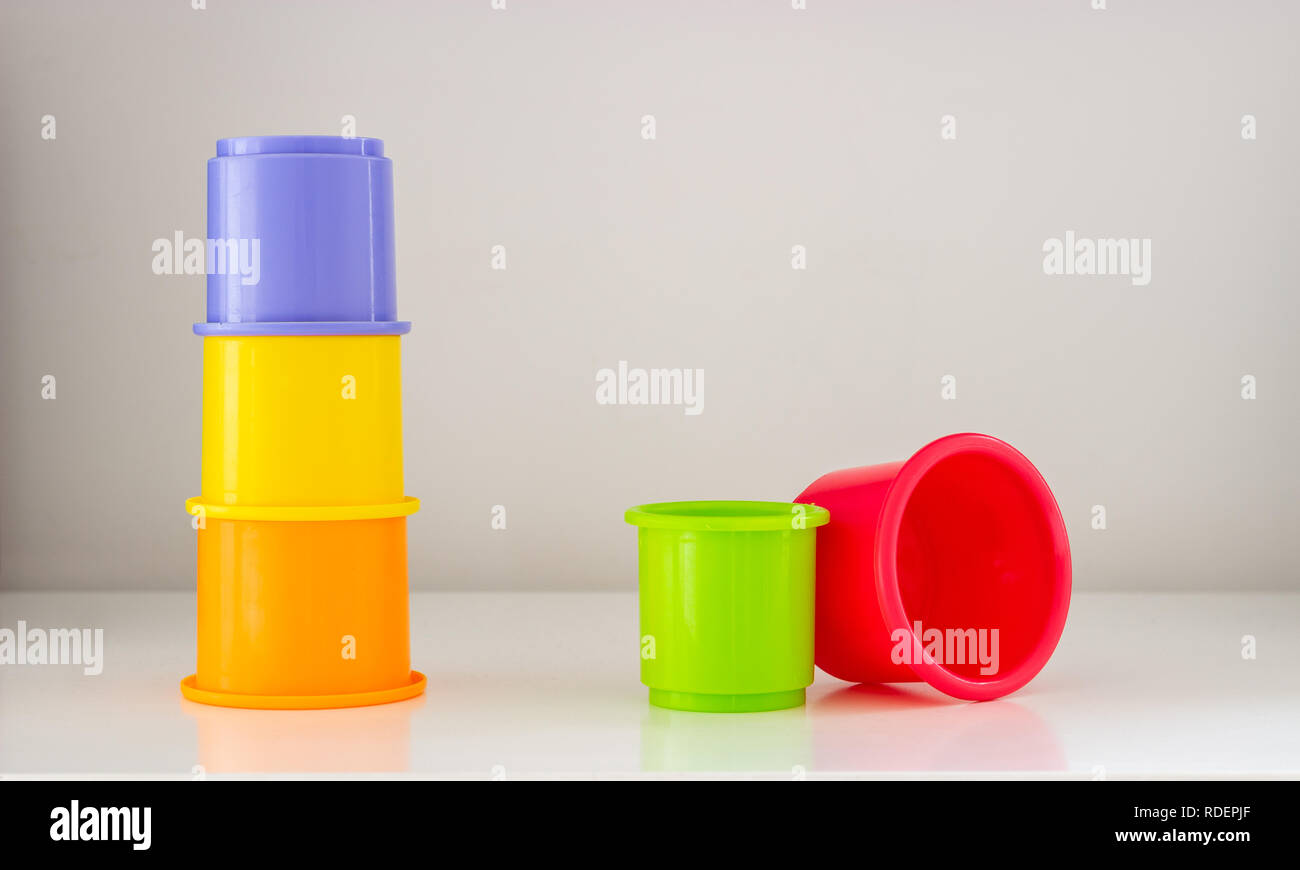 Toy stacking cups in bright colours on a white background with copy ...