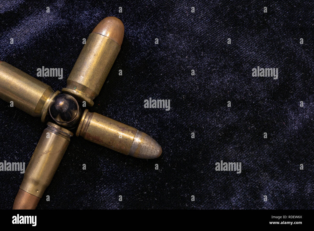 Pistol bullets gathered together in the shape of a cross. War concept ...
