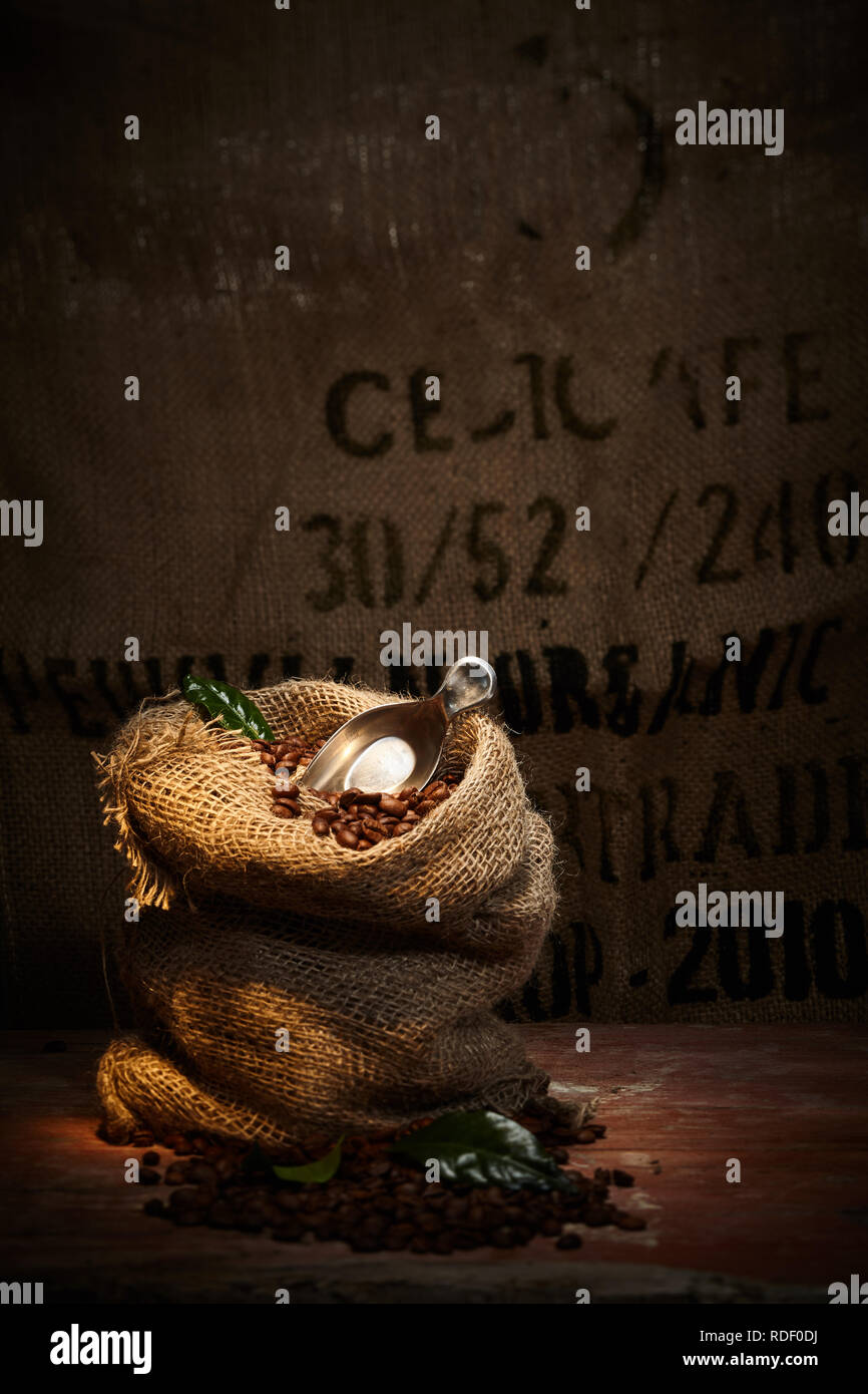 Sackful of fresh roasted coffee beans on a dark rustic background with copy space and rear ...