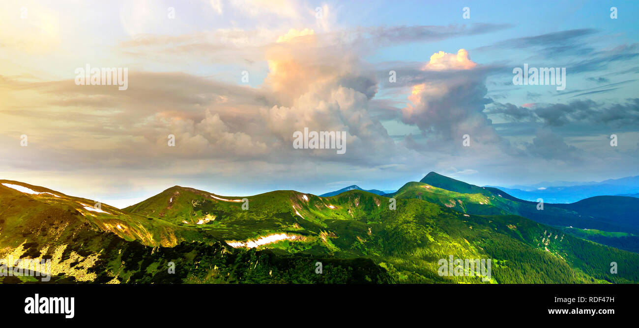 Wide panorama of lit by morning sun green valley, hills covered with ...