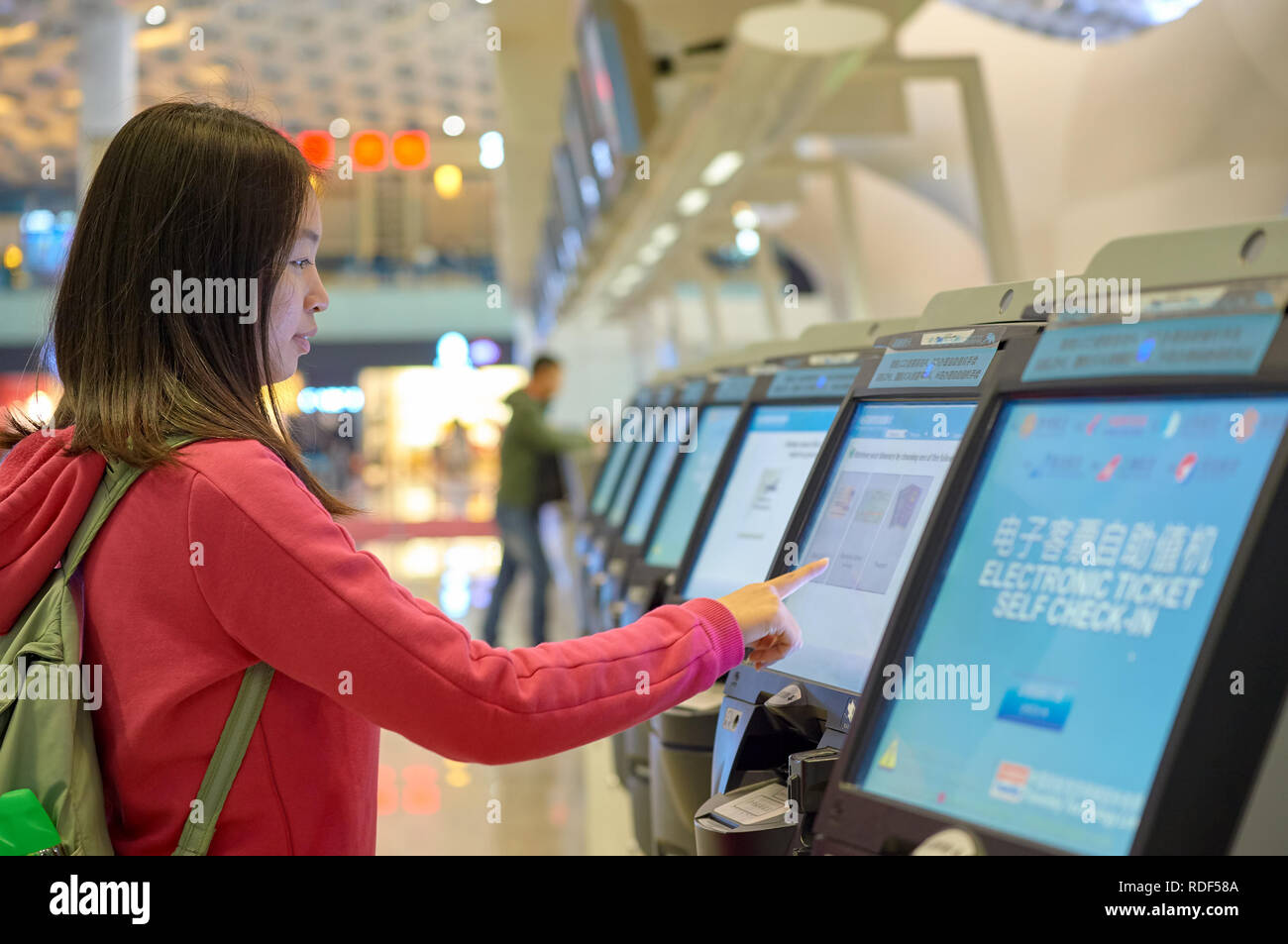 SHENZHEN, CHINA - FEBRUARY 16, 2015: woman use self check-in kiosk at ...
