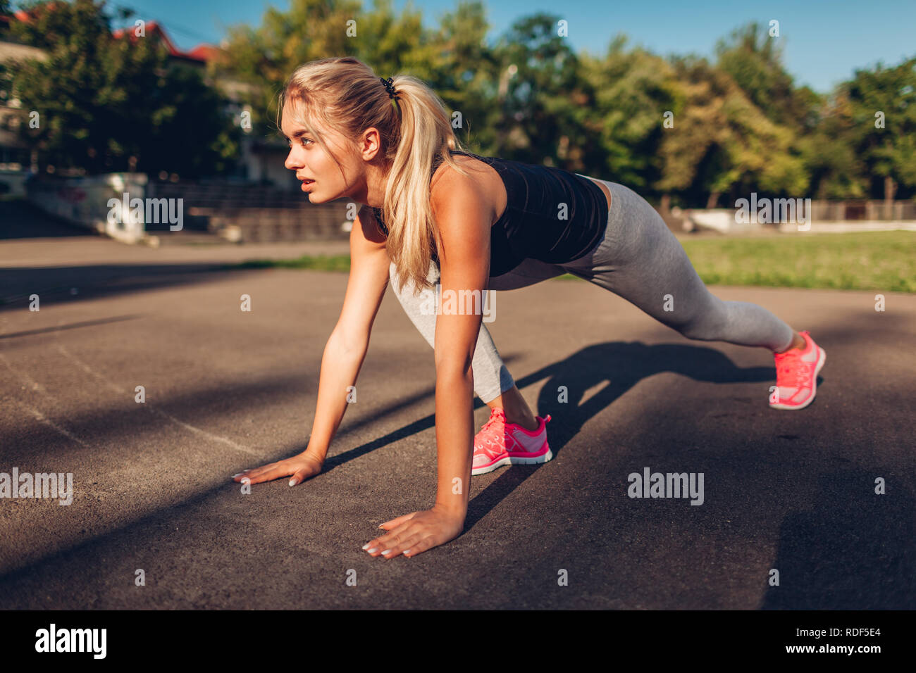 Young woman runner getting off to an early start on sportsground in ...