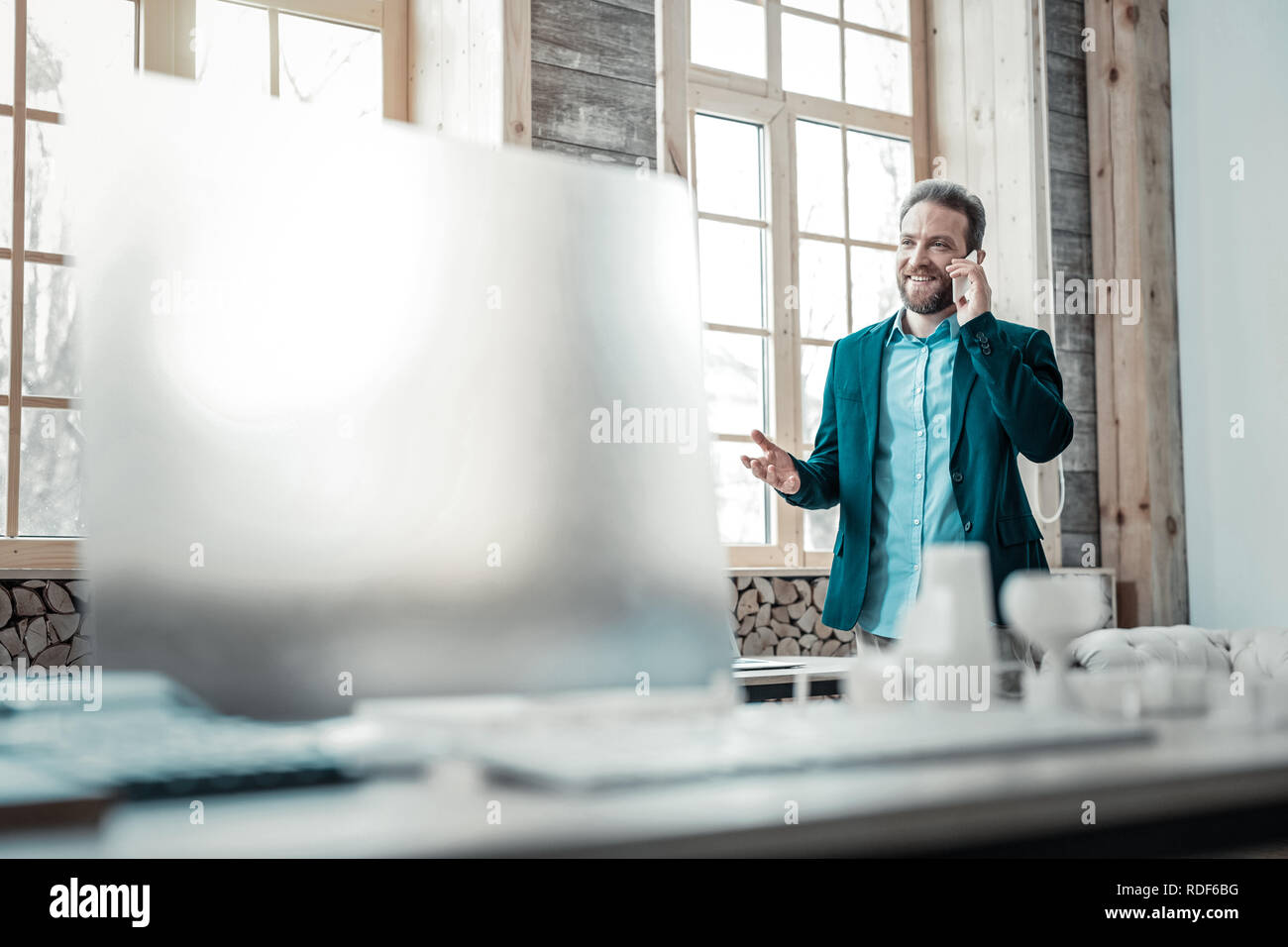 Professional businessman standing near window at his working place ...