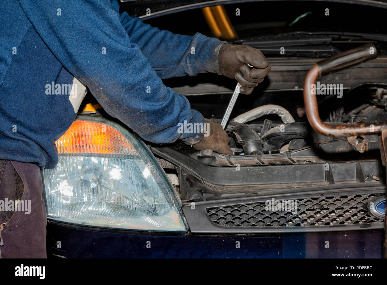The mechanic works on repairing a car's engine Stock Photo - Alamy