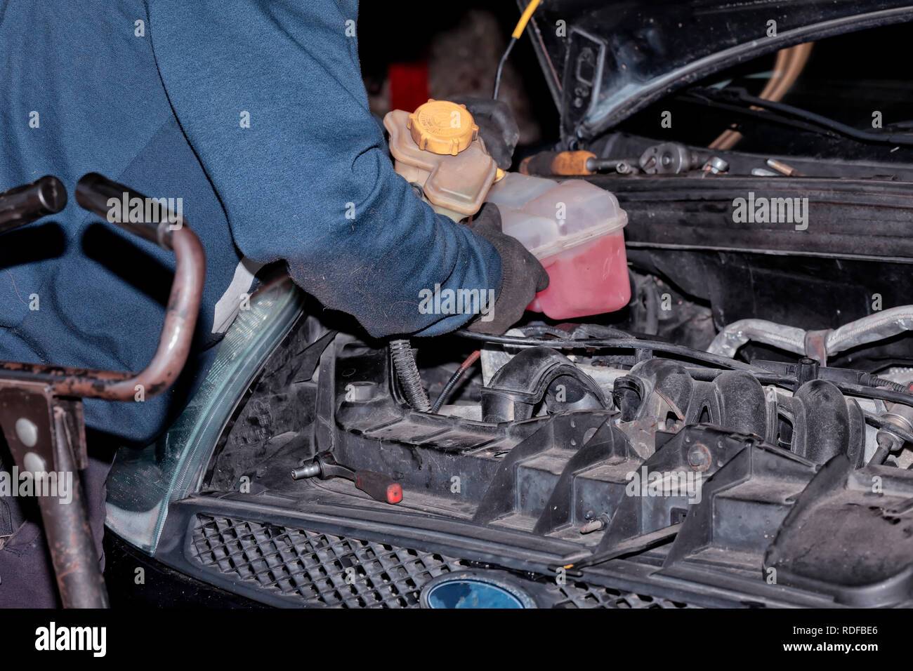 The mechanic works on repairing a car's engine Stock Photo - Alamy