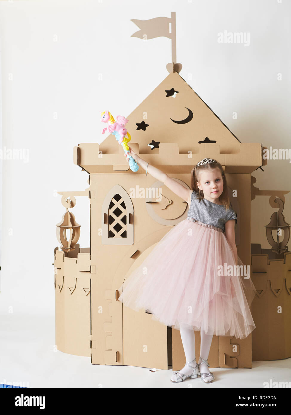 Beautiful little girl in princess dress playing with her toy castle ...