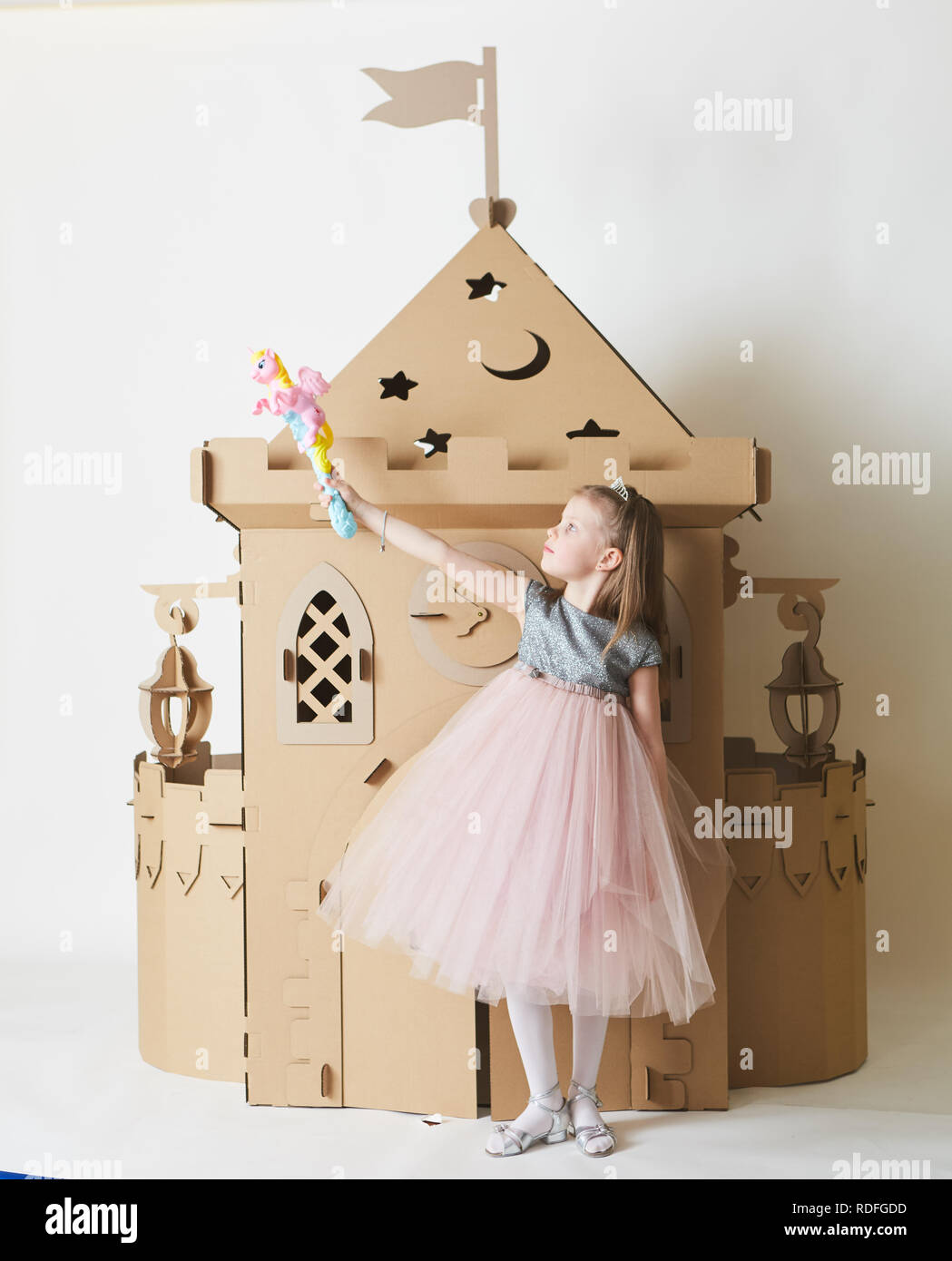 Beautiful little girl in princess dress playing with her toy castle ...