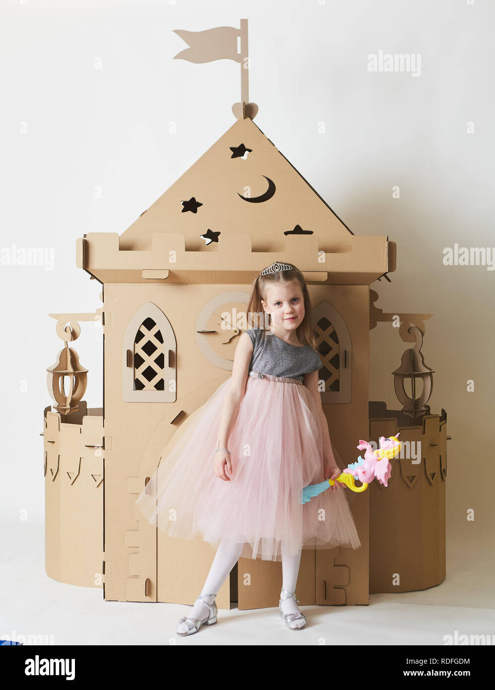 Beautiful little girl in princess dress playing with her toy castle ...