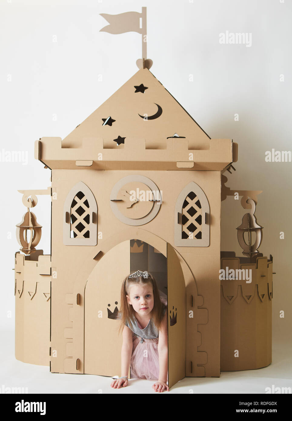 Beautiful little girl in princess dress playing with her toy castle ...