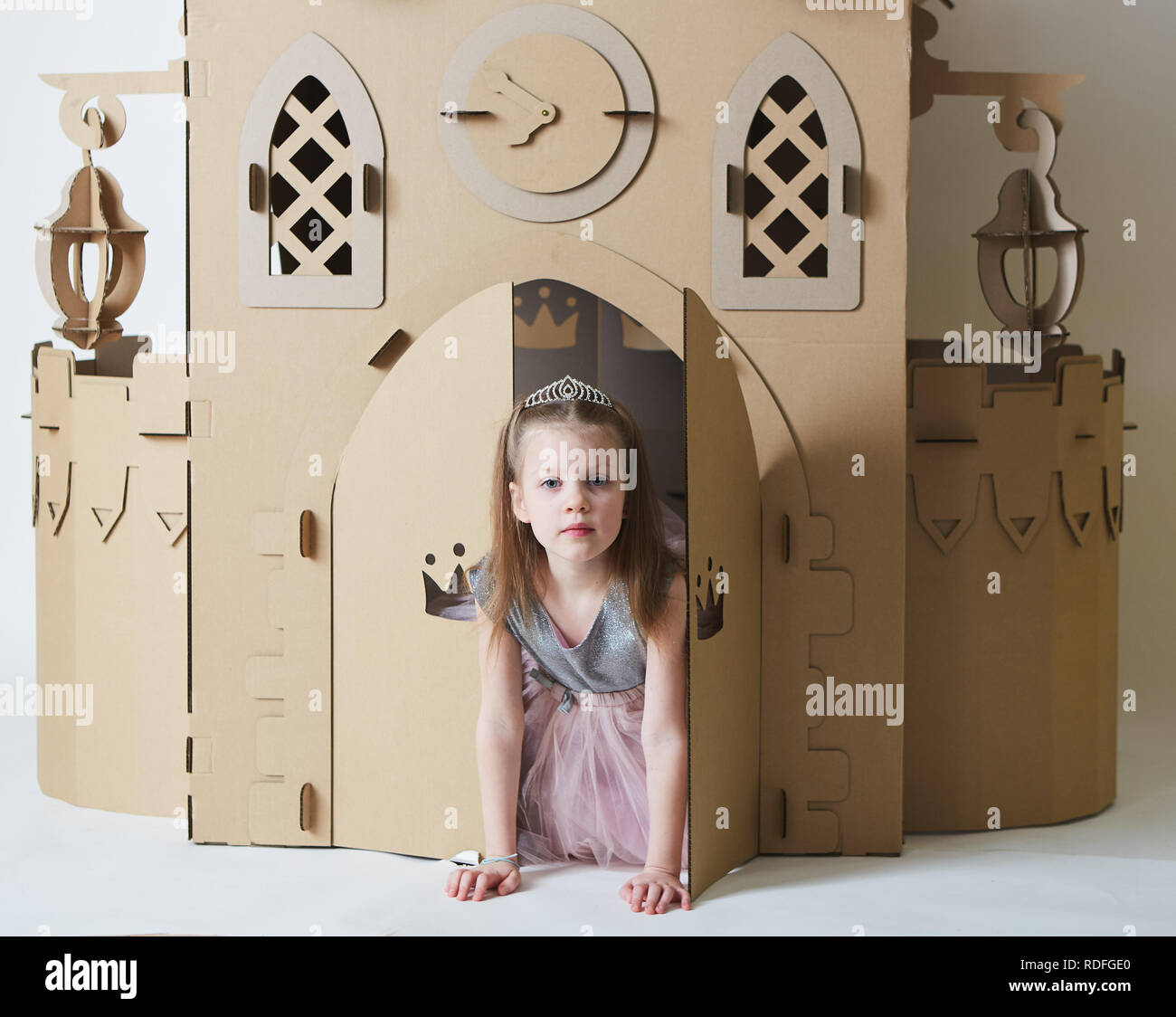 Beautiful little girl in princess dress playing with her toy castle ...