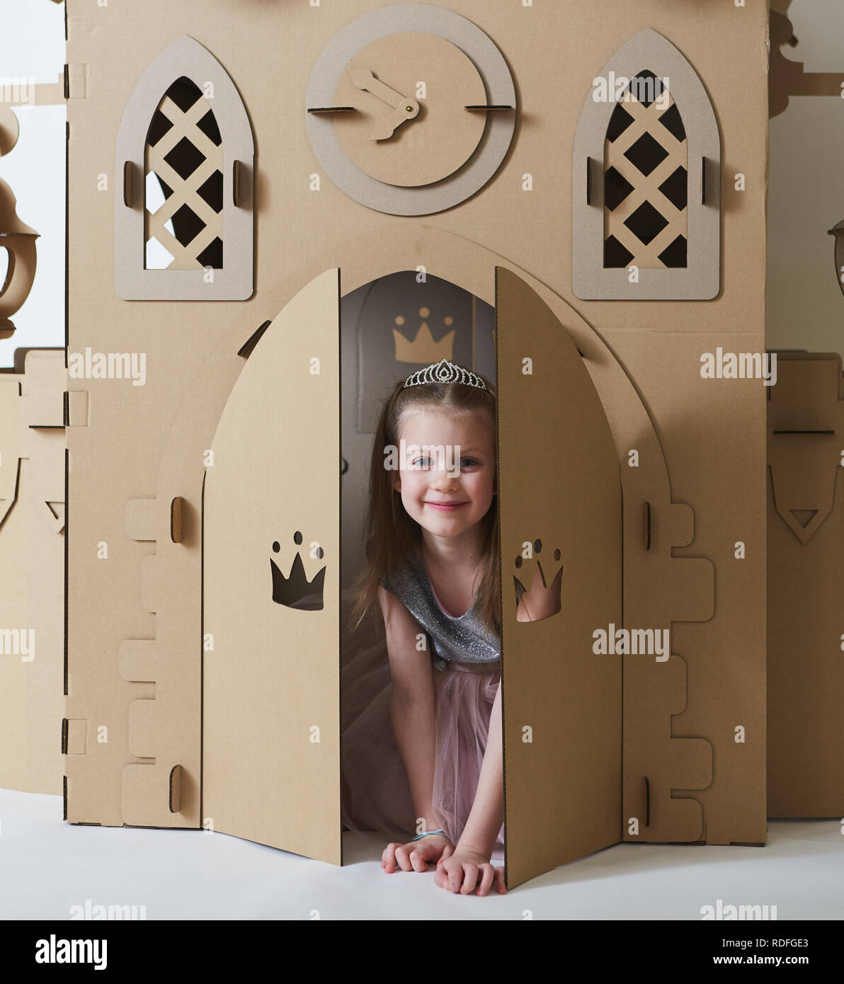 Beautiful little girl in princess dress playing with her toy castle ...