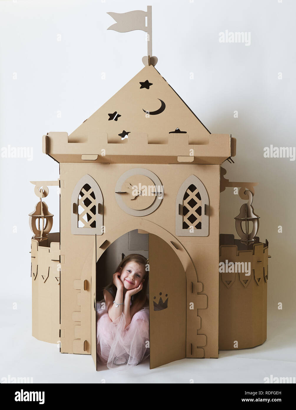 Beautiful little girl in princess dress playing with her toy castle ...