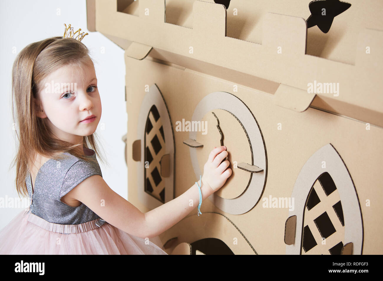 Beautiful little girl in princess dress playing with her toy castle ...
