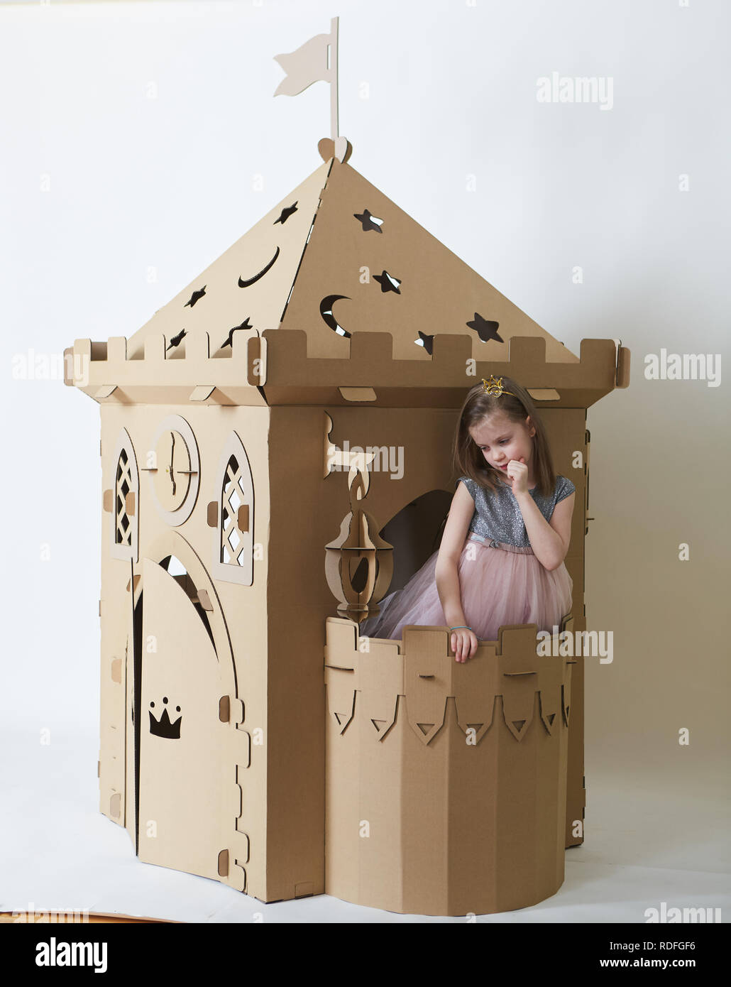 Beautiful little girl in princess dress playing with her toy castle ...