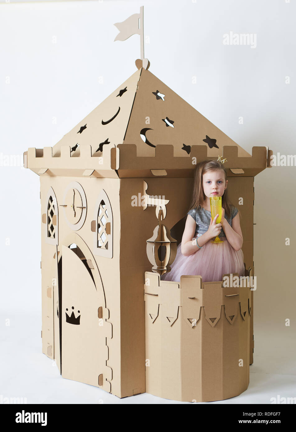 Beautiful little girl in princess dress playing with her toy castle ...