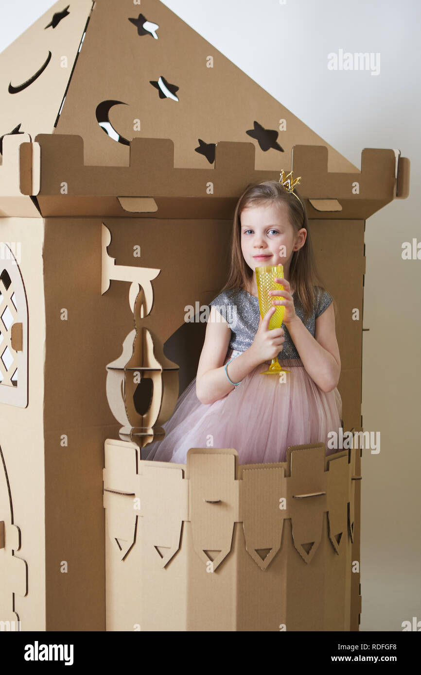 Beautiful little girl in princess dress playing with her toy castle ...