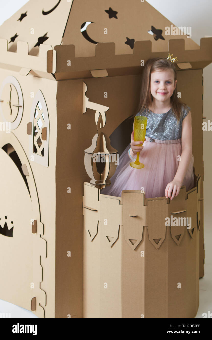 Beautiful little girl in princess dress playing with her toy castle ...