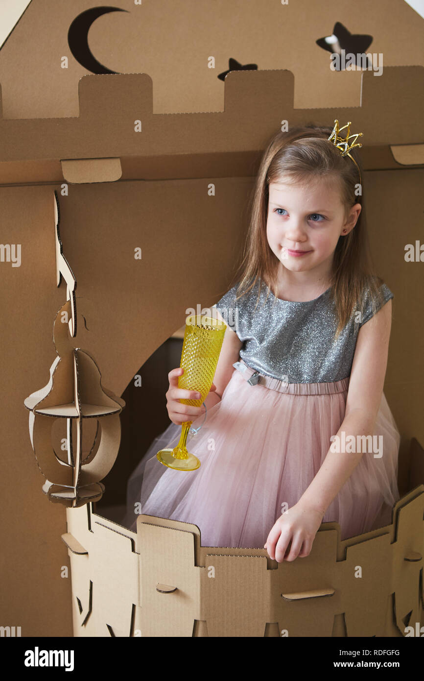 Beautiful little girl in princess dress playing with her toy castle ...